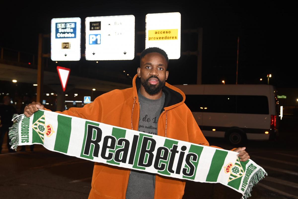 Cédric Bakambu llega a Sevilla con la bufanda del Betis